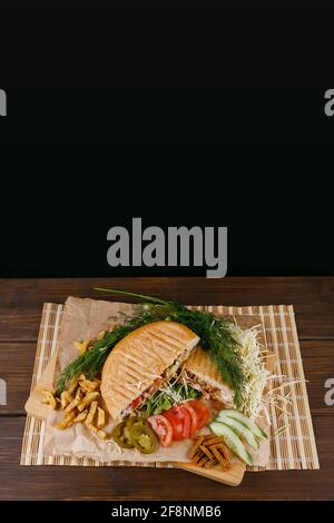 Fresh hot fragrant shawarma cut lies on a wooden board with vegetables ...