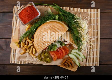 Fresh hot fragrant shawarma cut lies on a wooden board with vegetables ...
