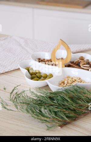 A festive plate served with nuts and other snacks in a bright ...