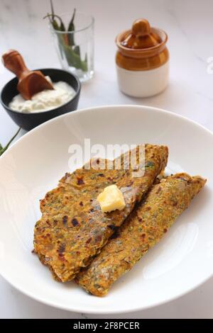 Radish or Mooli masala Paratha served on a white plate with butter ...