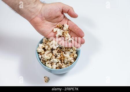 spoiled burnt popcorn in a blue cup. man's hand close up Stock Photo ...