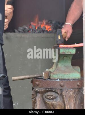 blacksmiths use hammers to form an iron detail Stock Photo - Alamy