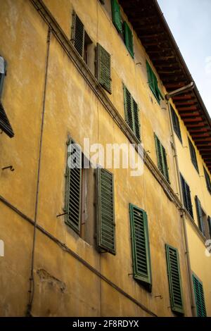 Green shuttered windows on a yellow colored Atrani building, Italy ...