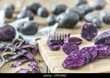 Raw peeled and sliced potatoes in glass bowls on color wooden ...