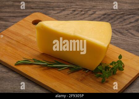 Hard cheese piece served rosemary and basil Stock Photo - Alamy