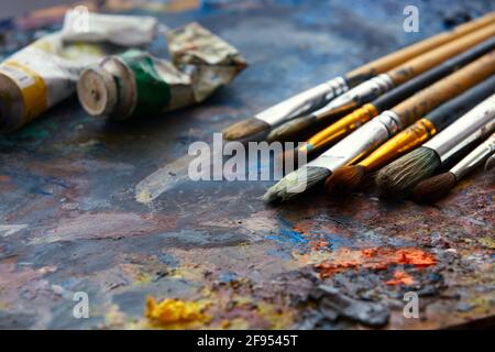 Artist palette with oil paints and brushes on a wooden background ...