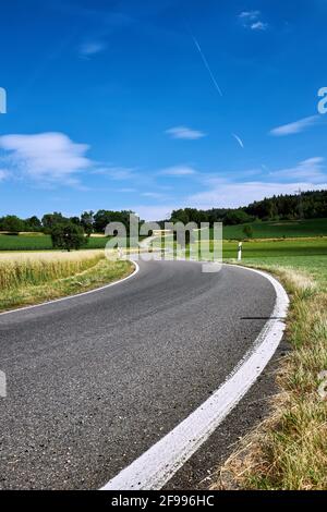Road with switchback curves winding through a valley with peaked ...