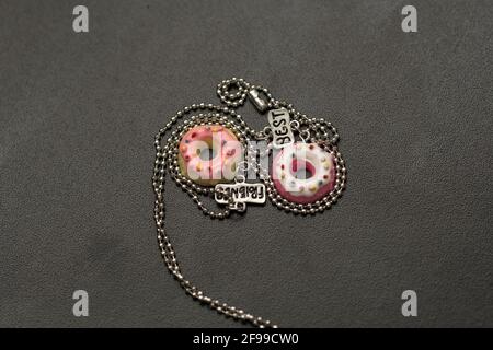 Pendant set of best friends two donuts necklace closeup. Selective ...
