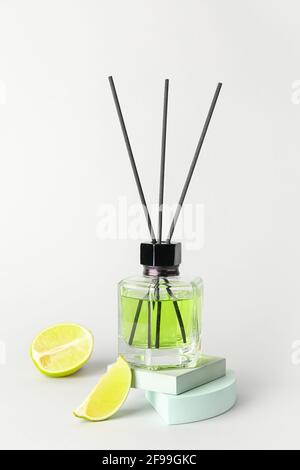 Reed diffuser with lime on light background Stock Photo - Alamy