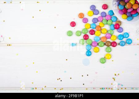 Colored candy bonbons scattered on white wooden board background Studio ...