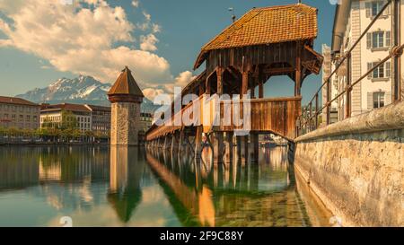 Scenic shot of the chapel bridge that goes over a lake in Lucerne ...