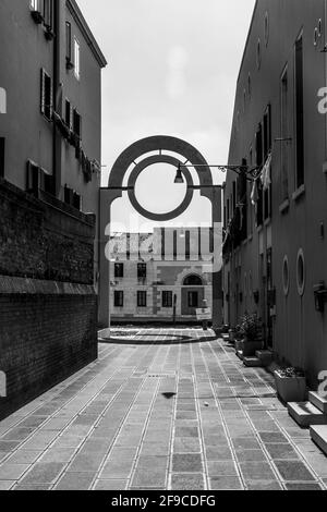A grayscale shot of a narrow path between buildings Stock Photo - Alamy