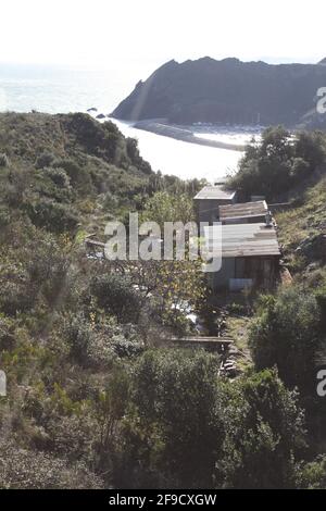 Corrugated-iron huts in a valley with an ocean view Stock Photo - Alamy