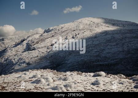 Picturesque view of mount with snow on bumpy surface under cloudy sky ...