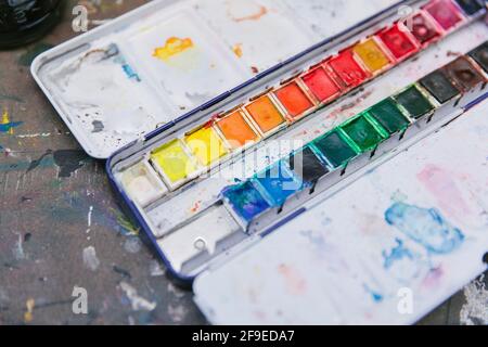 From above of watercolor paint palettes and abstract pictures arranged ...