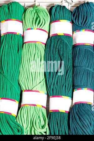 Rolls of polyester cord in various bright colors of green and beige ...