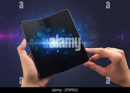 Businessman holding a foldable smartphone with DATABASE SECURITY ...