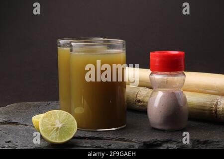 sugar cane juice or "ganne ka ras" with cut pieces cane on white ...
