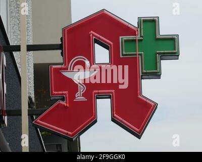 Red cross sign of a pharmacy in a street Stock Photo - Alamy