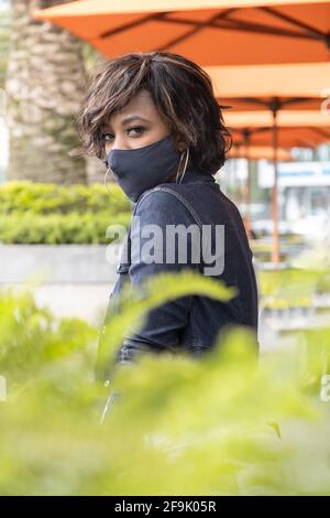 young beautiful woman wearing jean jacket texting on the smartphone ...