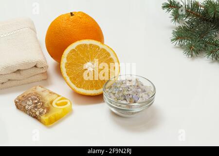 Cut orange with whole one, towel, bottle with aromatherapy oil and sea ...