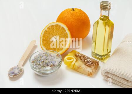 Cut orange with whole one, towel, bottle with aromatherapy oil and sea ...