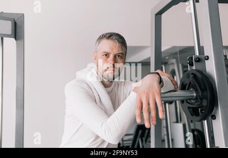 Portrait of a sports man. Athlete wipes his hands in a pine forest ...