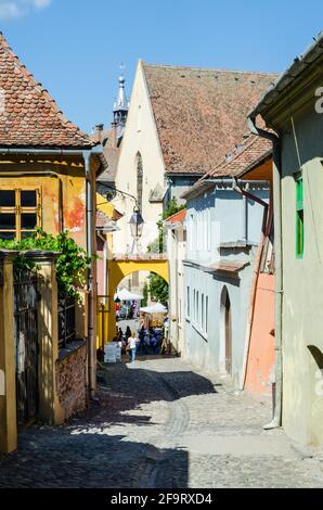 Stone paved old streets with colorful houses in Sighisoara fortress ...