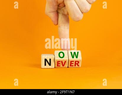 Now or never symbol. Businessman turns wooden cubes and changes the ...
