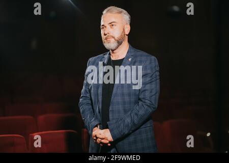 Elegant male theatre and movie director giving an interview in ...