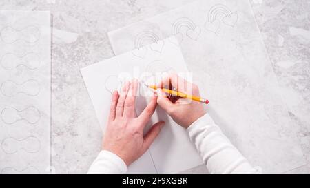 Flat lay. Step by step. Drawing outlines with pencil on parchment paper ...