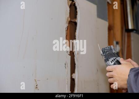 Cutting plasterboard plaster hand sawzall tool Stock Photo - Alamy