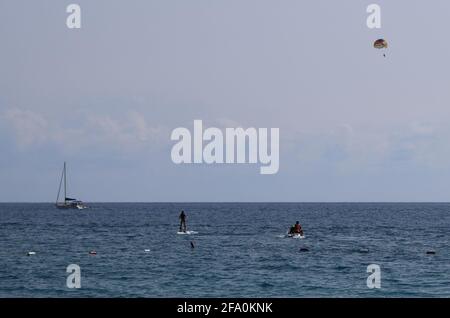 Silhouette of a fly board rider at sea and Parasailing in blue sky ...