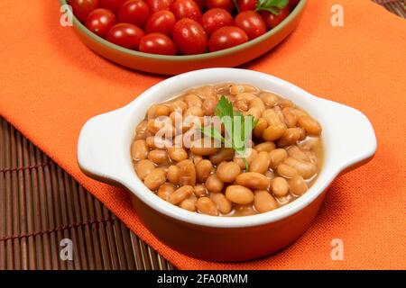 ceramic pot with carioca beans cooked (feijoada) on table with mat and ...