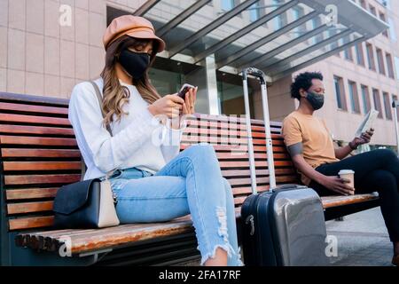 Tourist people waiting outside airport or train station Stock Photo - Alamy