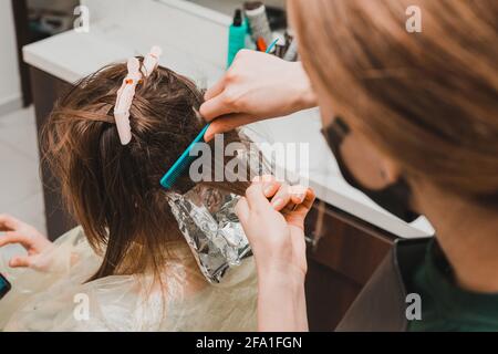 Hair coloring during the quarantine period, client and hairdresser in ...