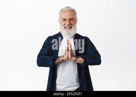 Thank you gesture. Handsome grateful man holding hands near heart pink ...