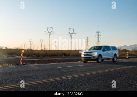 Electric pylons at sunset. Cars drive by on street Stock Photo - Alamy