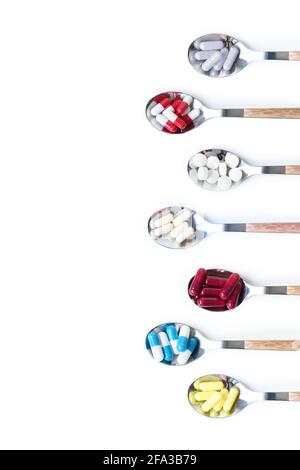 Top view Variety of vitamin and mineral pills in wooden spoon on ...