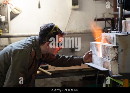 Traditional metalworking process in a forge.The master blacksmith works ...