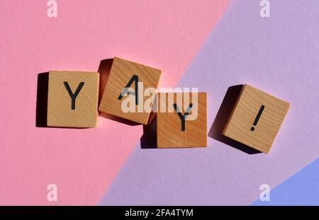 Yay, word in wooden alphabet letters isolated on bright pink background ...
