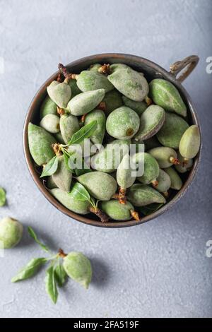 Bowl of fresh unripe almonds on gray background. Fresh raw green ...