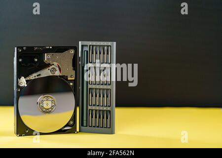 hdd disk with screwdriver repair kit on yellow black background Stock ...