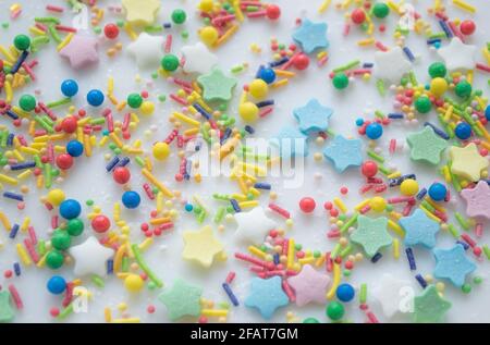 Multi-color festive background of a scattering of sugar candy sprinkles ...