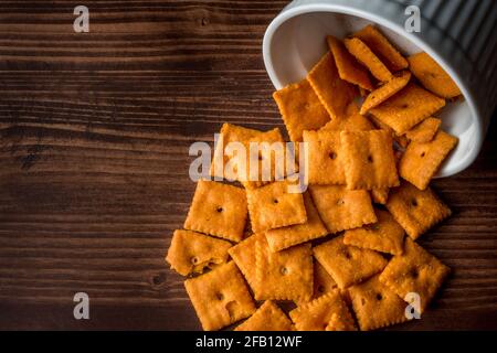 Crackers poured out on the wooden table from the bowl Stock Photo - Alamy