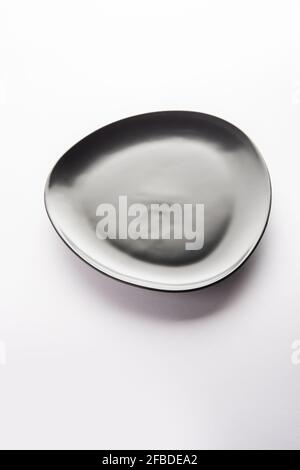 Empty triangle shape black ceramic plate isolated on white background ...