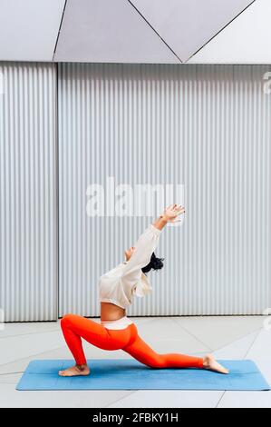 Female athlete doing backbend pose by a white wall Stock Photo - Alamy
