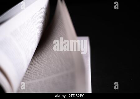 Scrolling pages in an English novel book. isolated open book in a dark ...