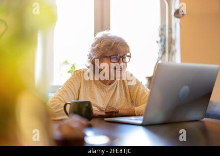 happy elderly woman using laptop computer at home. Senior mature older ...