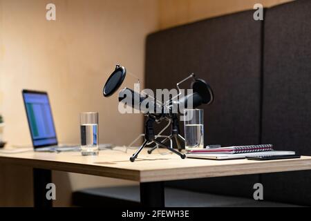 Office desk with microphones, documents, laptop computer, glasses of ...